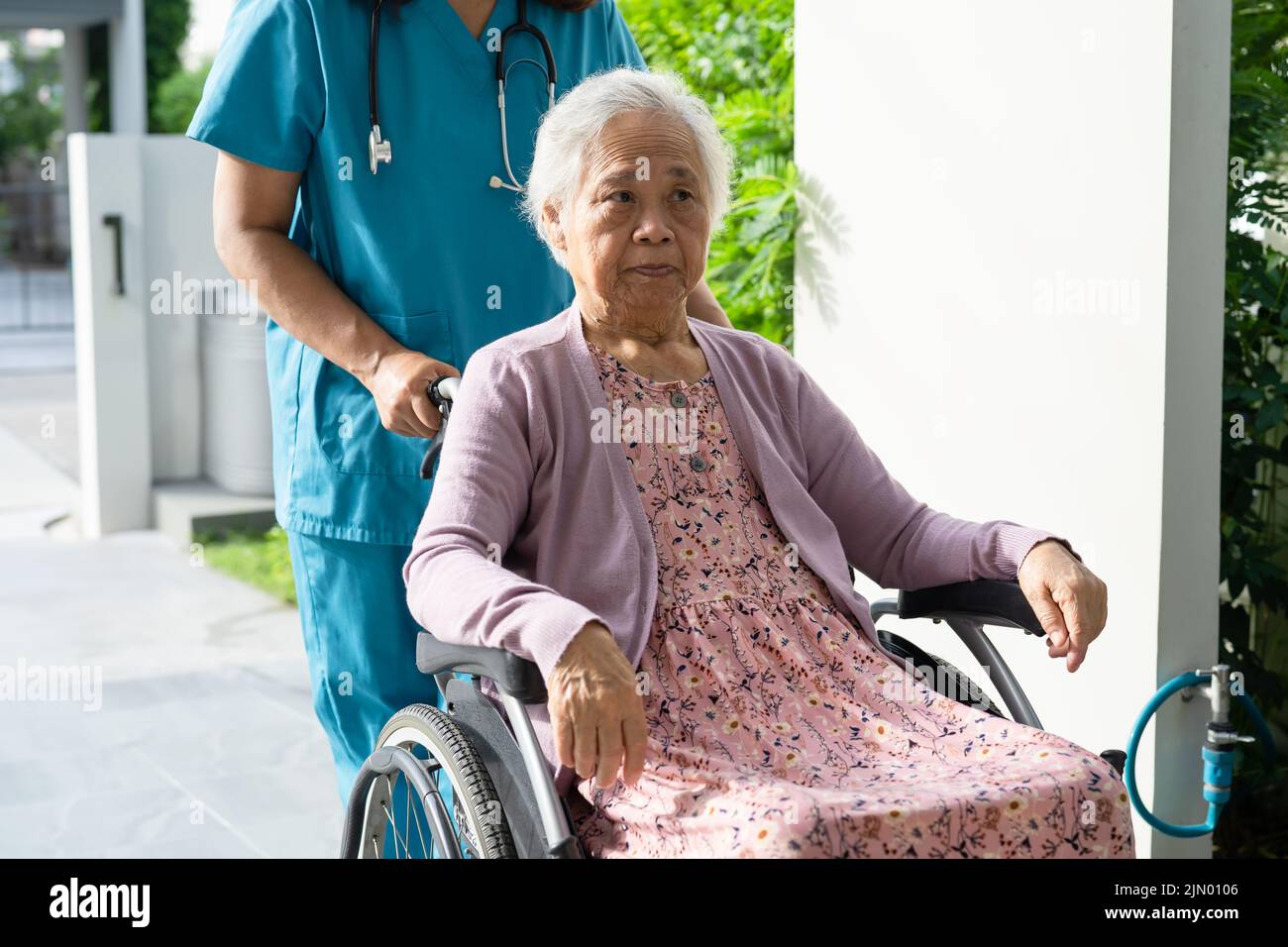 Doctor caregiver help and care Asian senior or elderly old lady woman patient sitting on ...