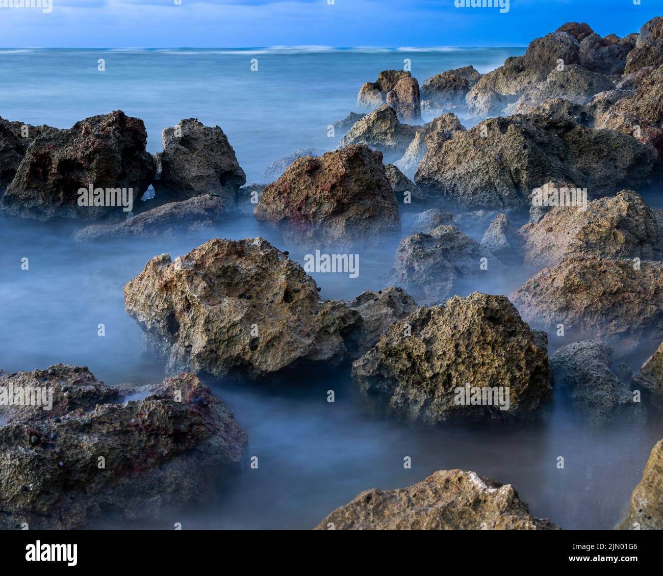 A landscape of a clean ocean with huge rocks in it Stock Photo - Alamy