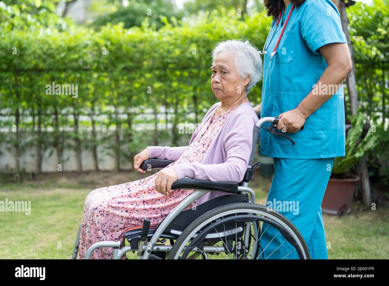 Doctor caregiver help and care Asian senior or elderly old lady woman patient sitting on ...