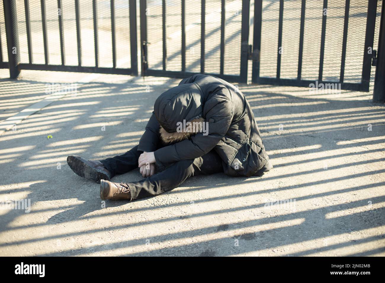 Guy is sitting on pavement. Homeless man on street. Drunk went ...
