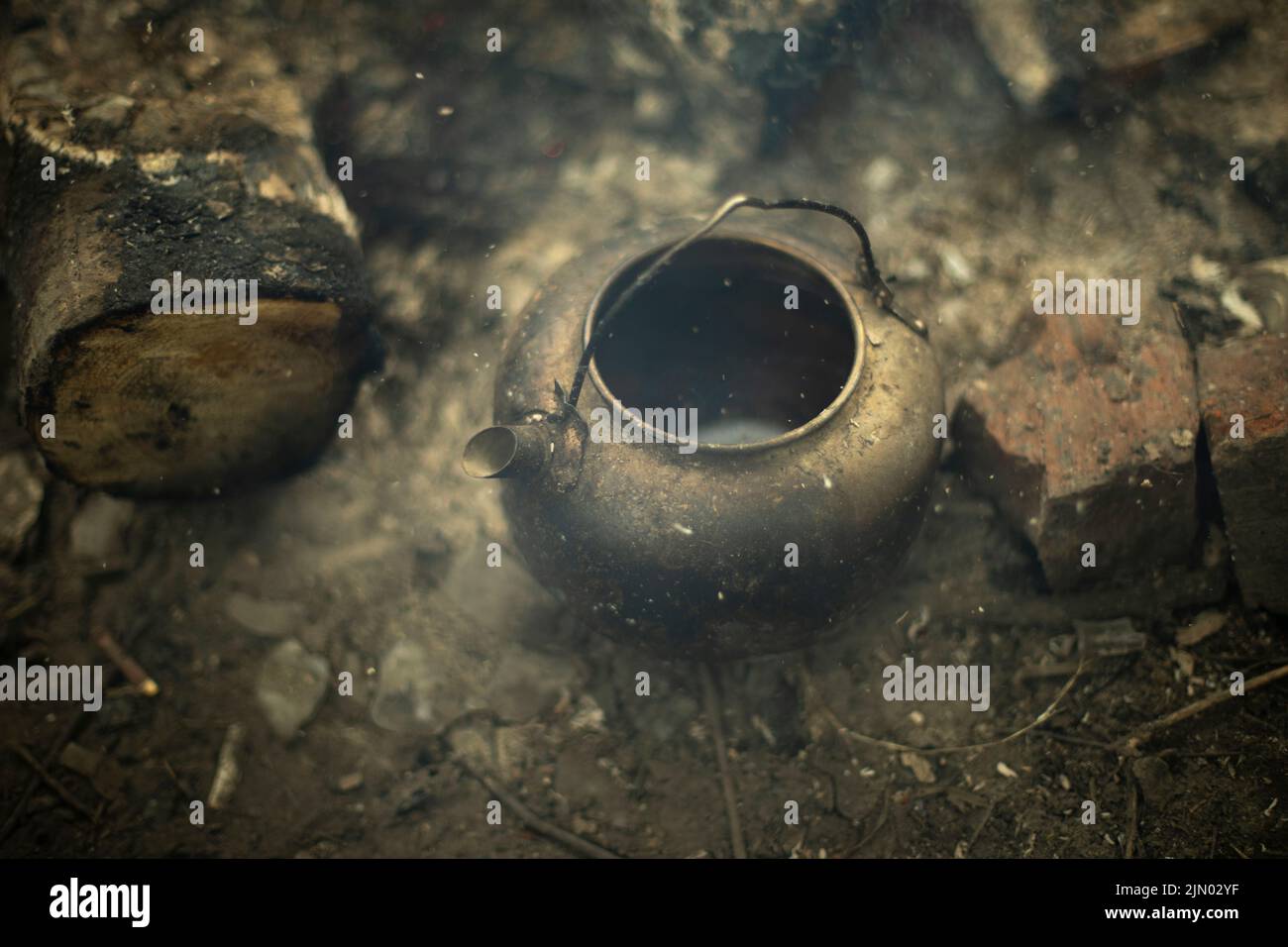 Kettle on fire. Cooking tea on coals. Camping details. Steel cookware ...