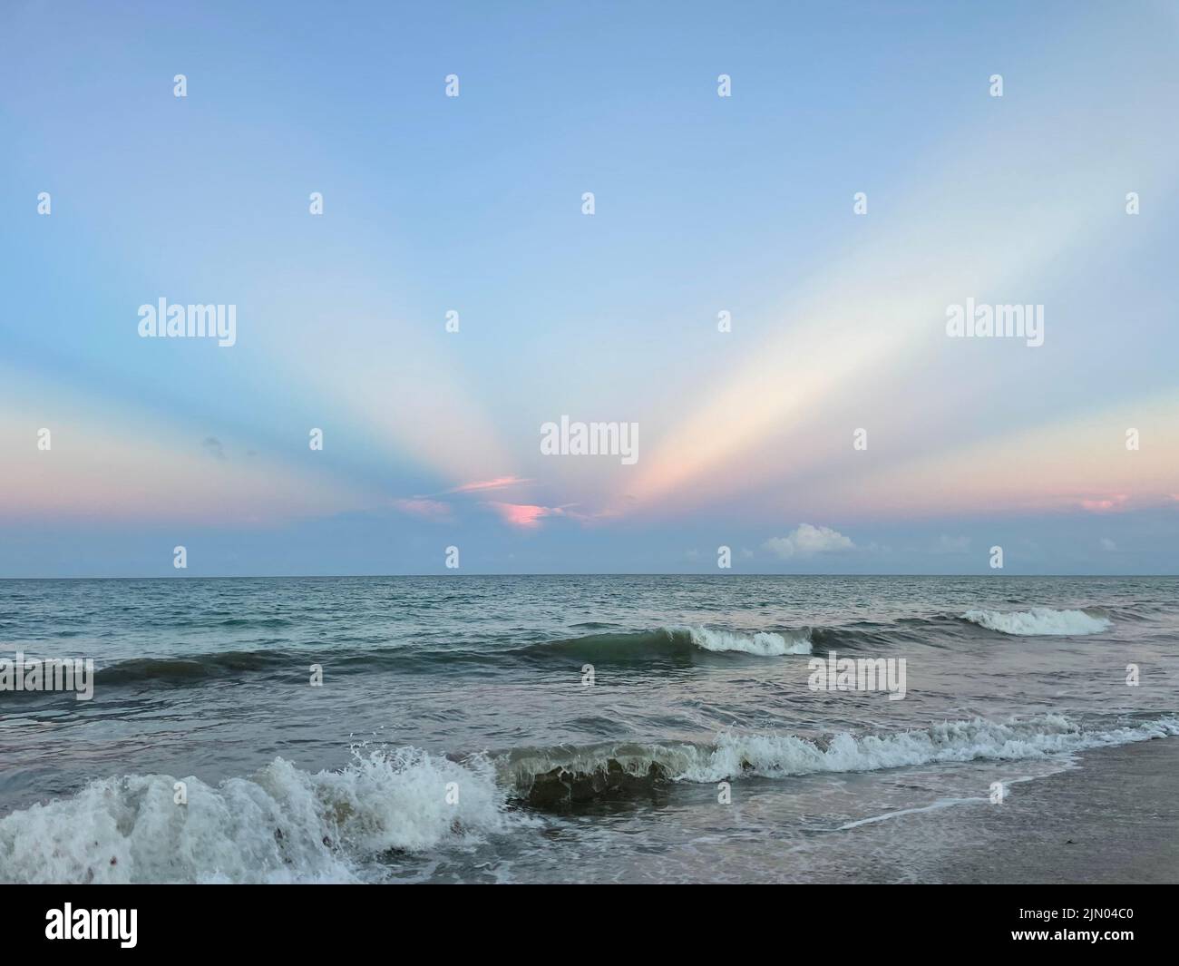 The beautiful sunset in the wavy beach Stock Photo - Alamy