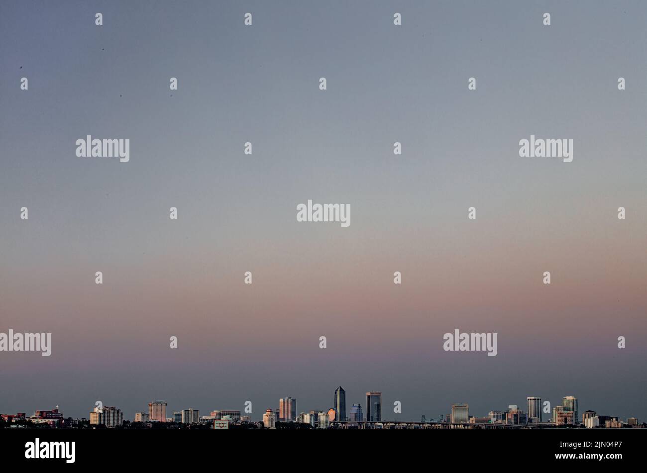 The tops of the modern city buildings under the blue purple shaded sky ...