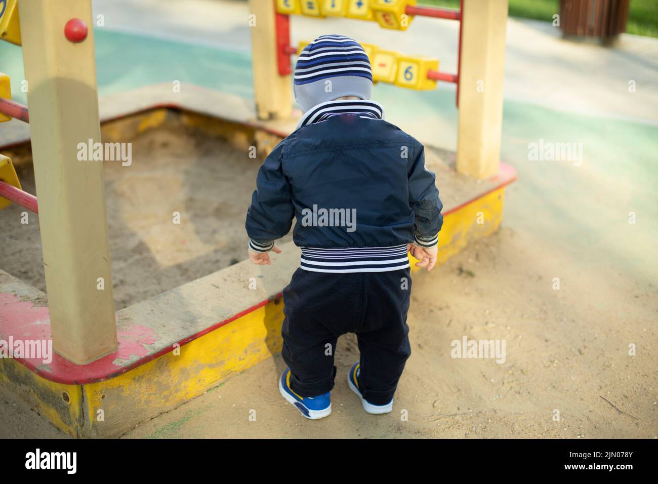 Child in sandbox. Preschooler on playground. Little boy digs ground ...