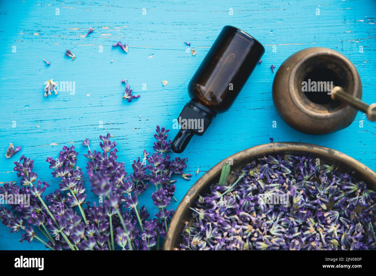Flat lay of oil, bowl and bouquet of fresh lavender flowers on ...