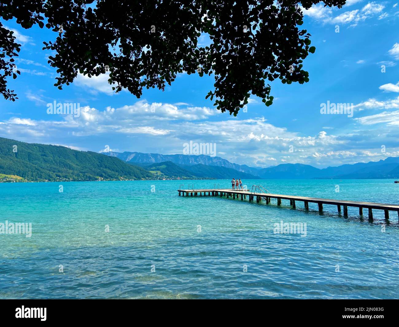 The seascape view with young people standing on the wooden dock under ...