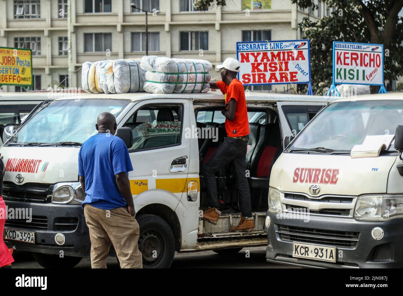 Nakuru, Kenya. 08th Aug, 2022. A bus conductor packs luggage on top of ...