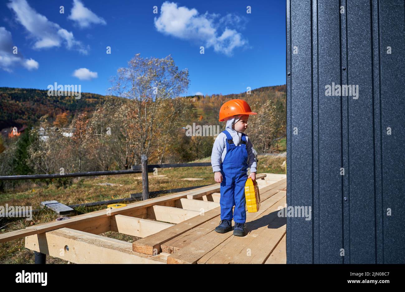 Boy toddler playing as builder on construction site. Child carpenter in ...