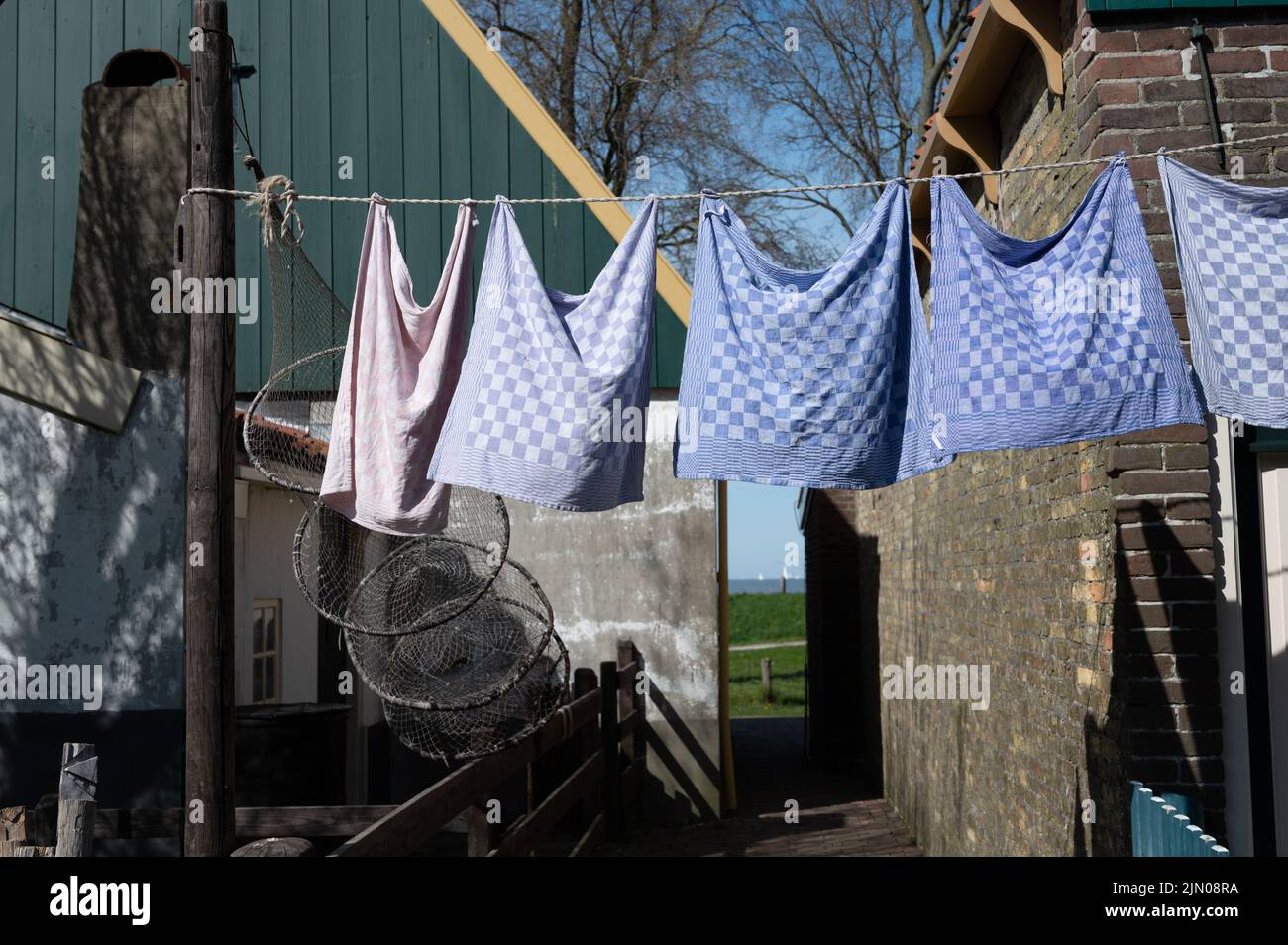 Old-fashioned laundry drying in wind on clotheslines. Walking in historical Dutch fisherman's ...