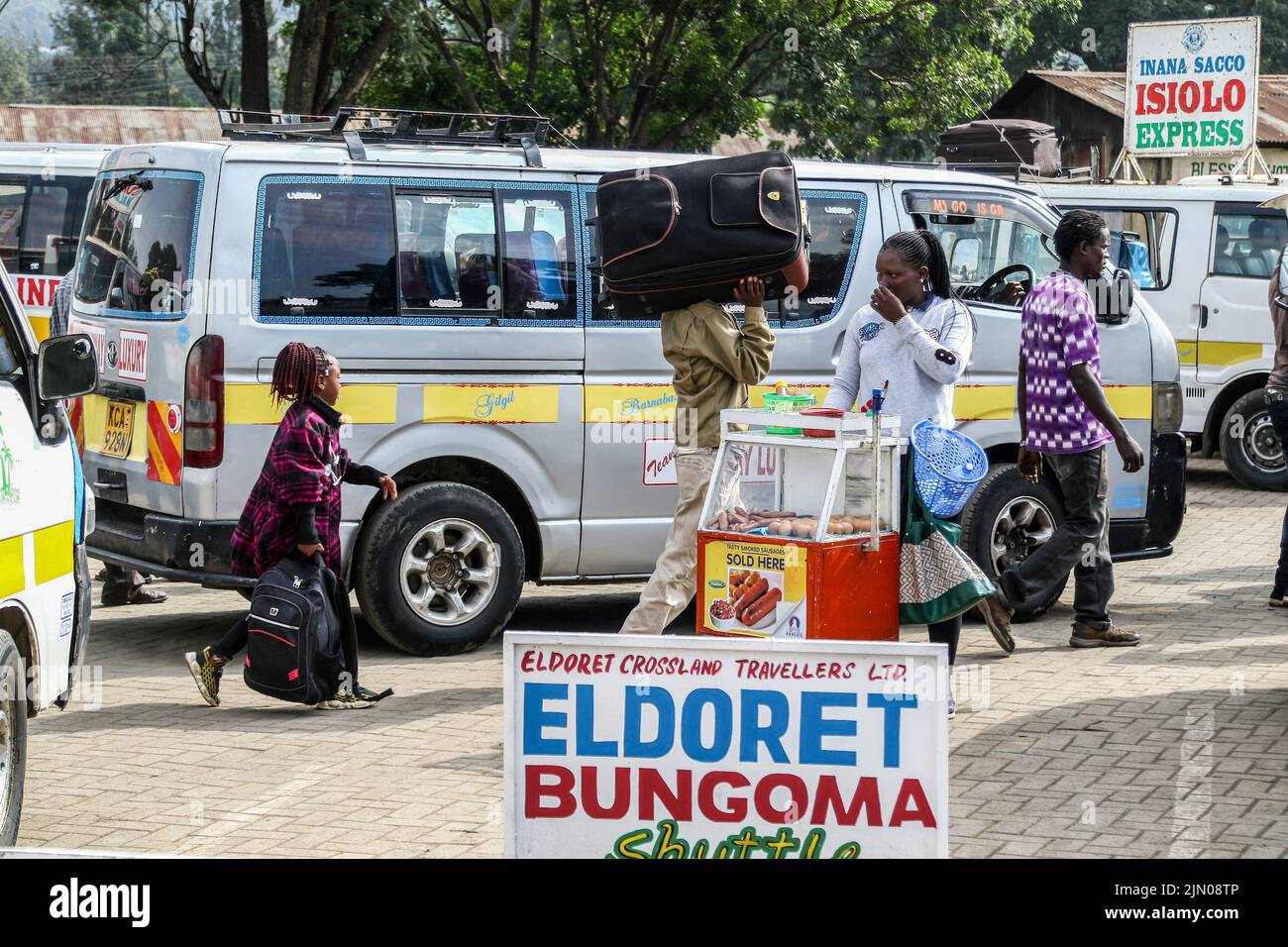 Travelers walk to board a minibus commonly known as a matatu at a bus ...
