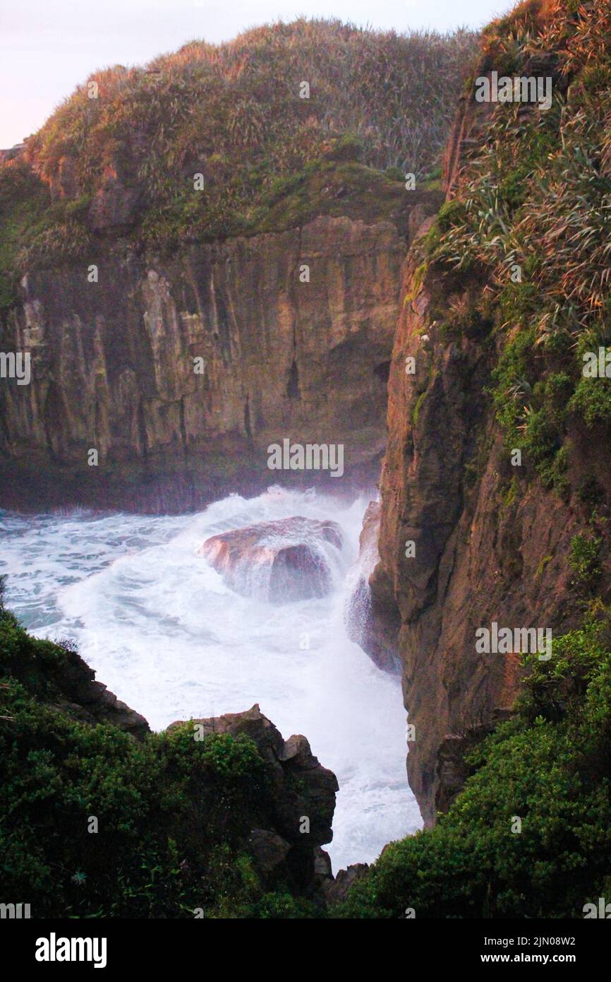 A vertical shot of crashing waves into cliffs Stock Photo - Alamy