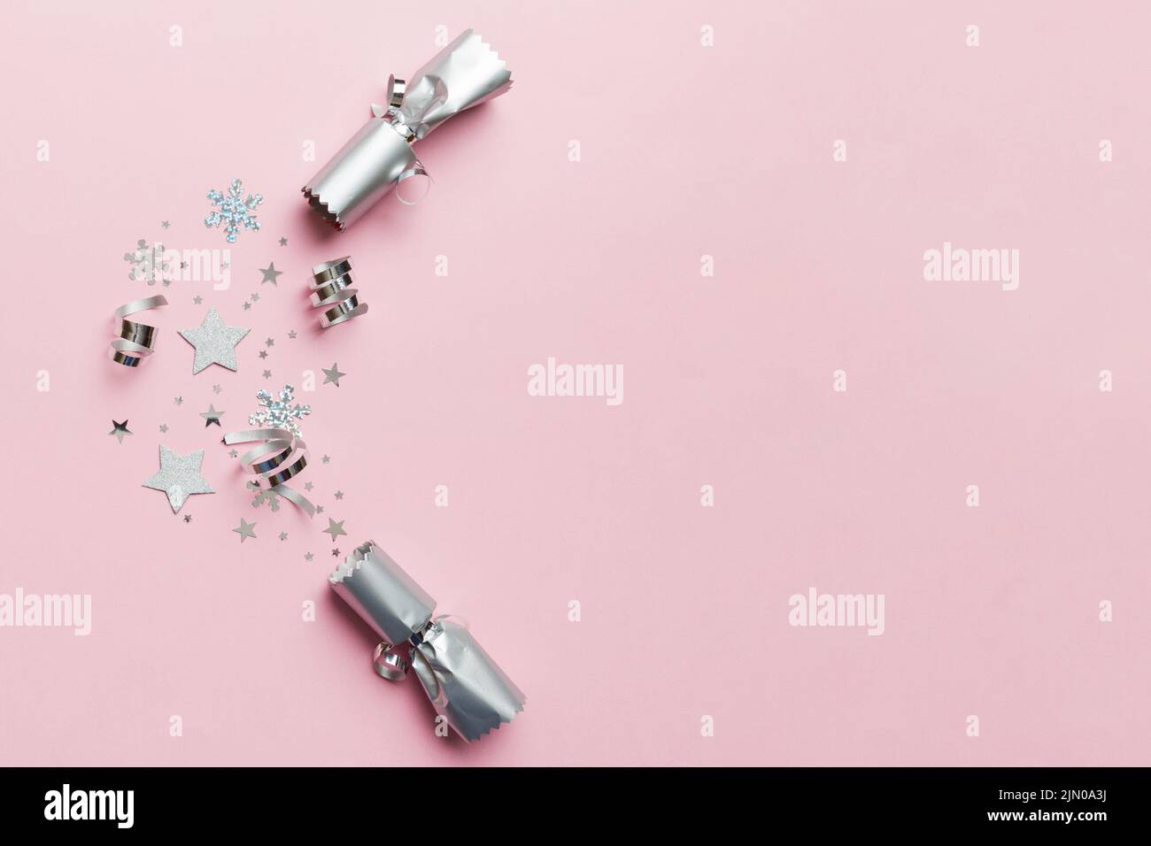 Christmas crackers with shiny confetti on color background, top view ...