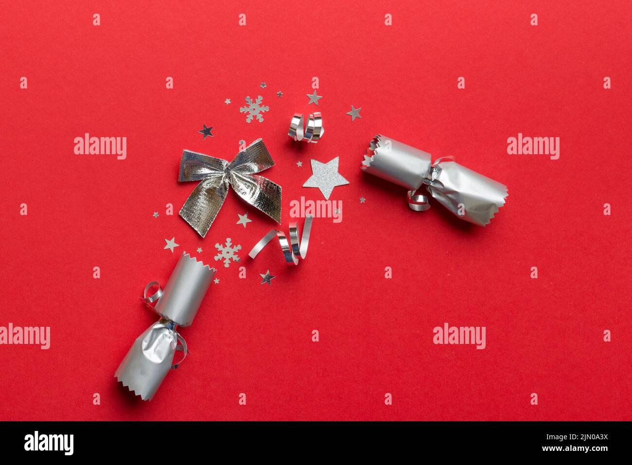 Christmas crackers with shiny confetti on color background, top view ...