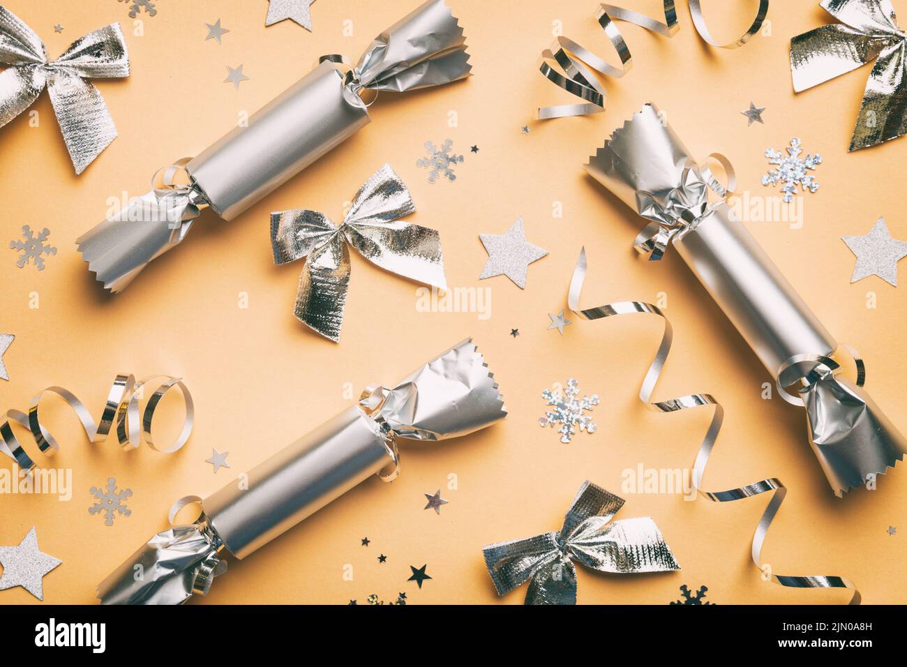 Christmas crackers with shiny confetti on color background, top view ...