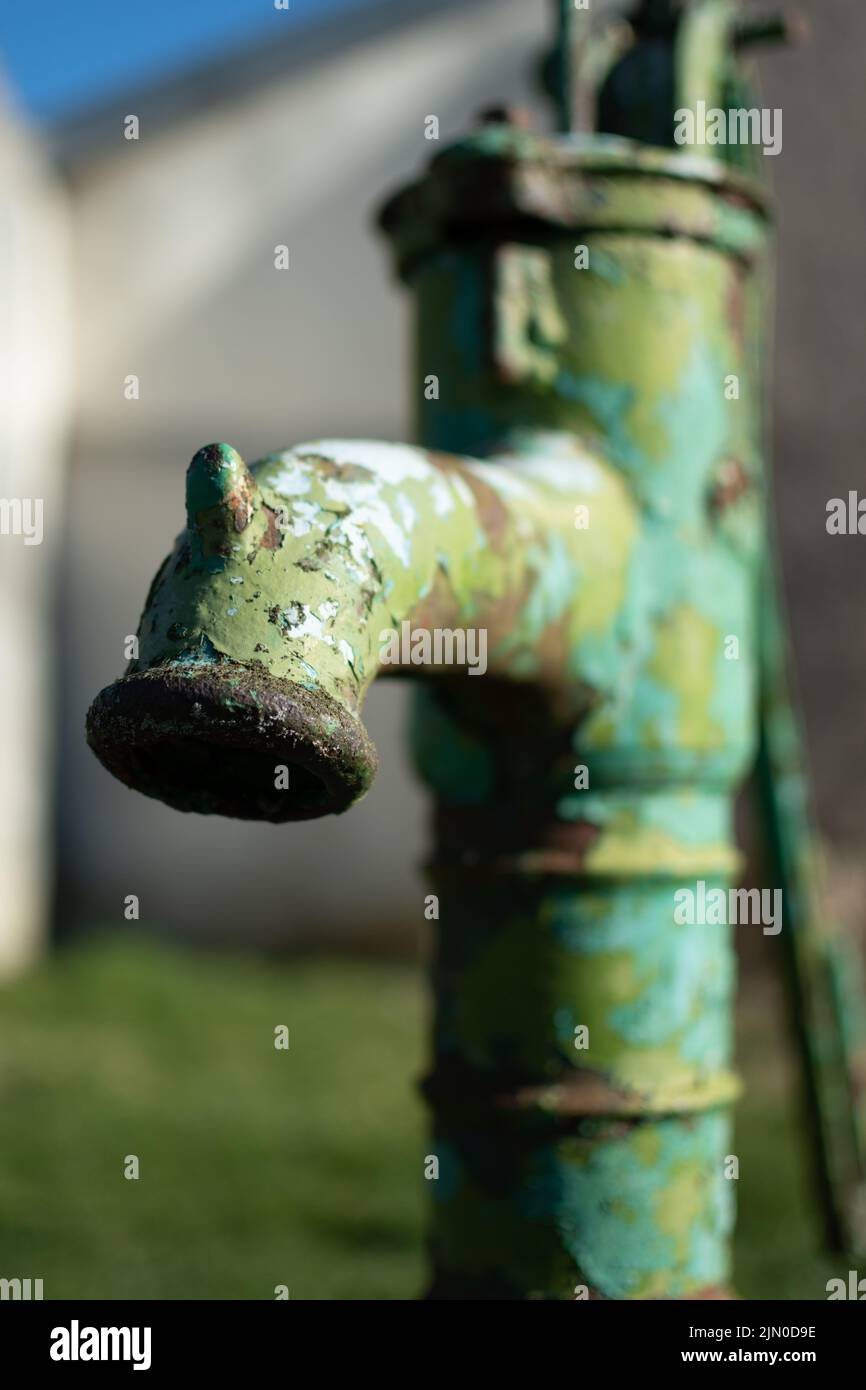 Old hand water pump on a well in the garden, watering and saving water ...