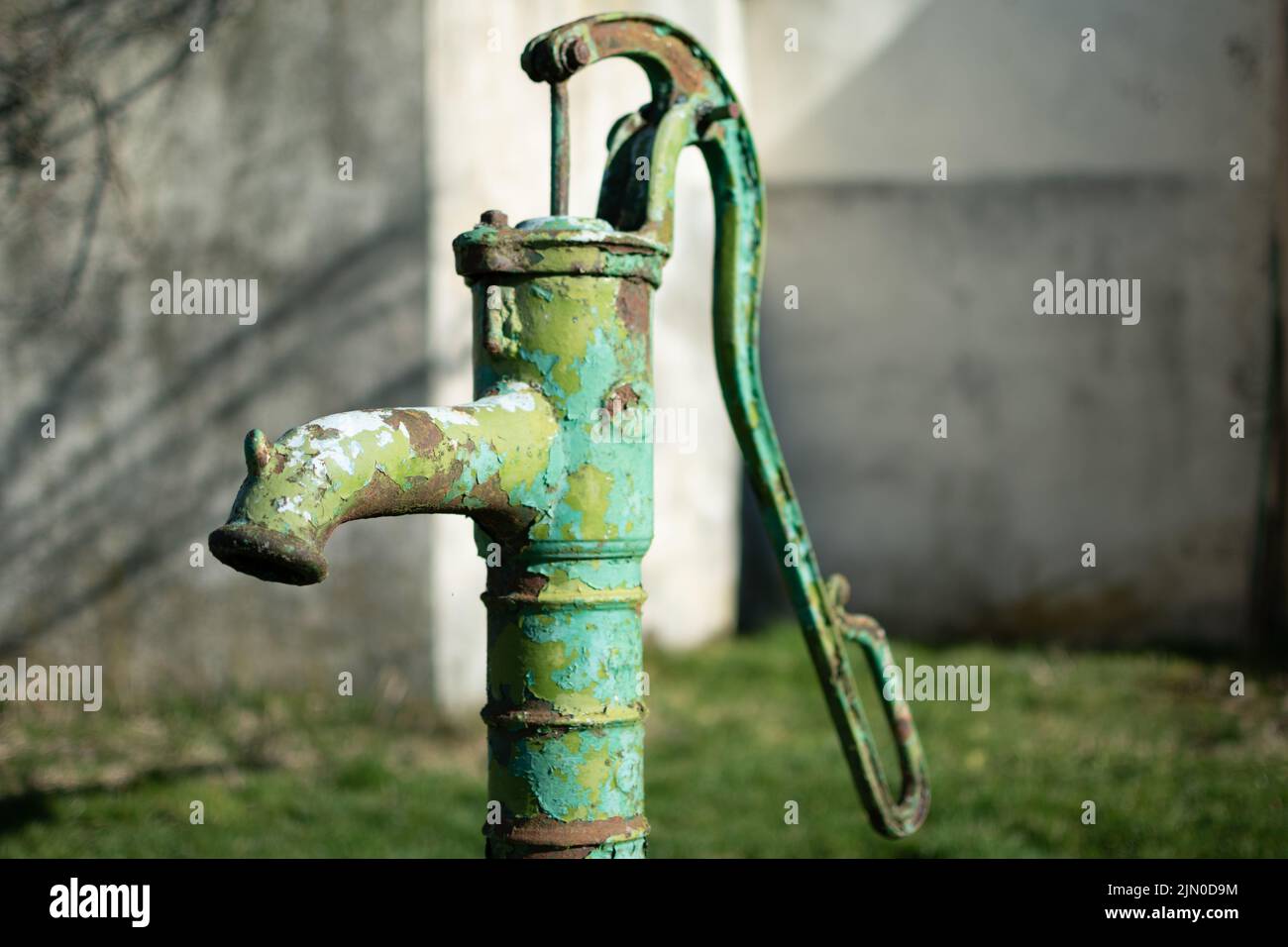 Old hand water pump on a well in the garden, watering and saving water ...