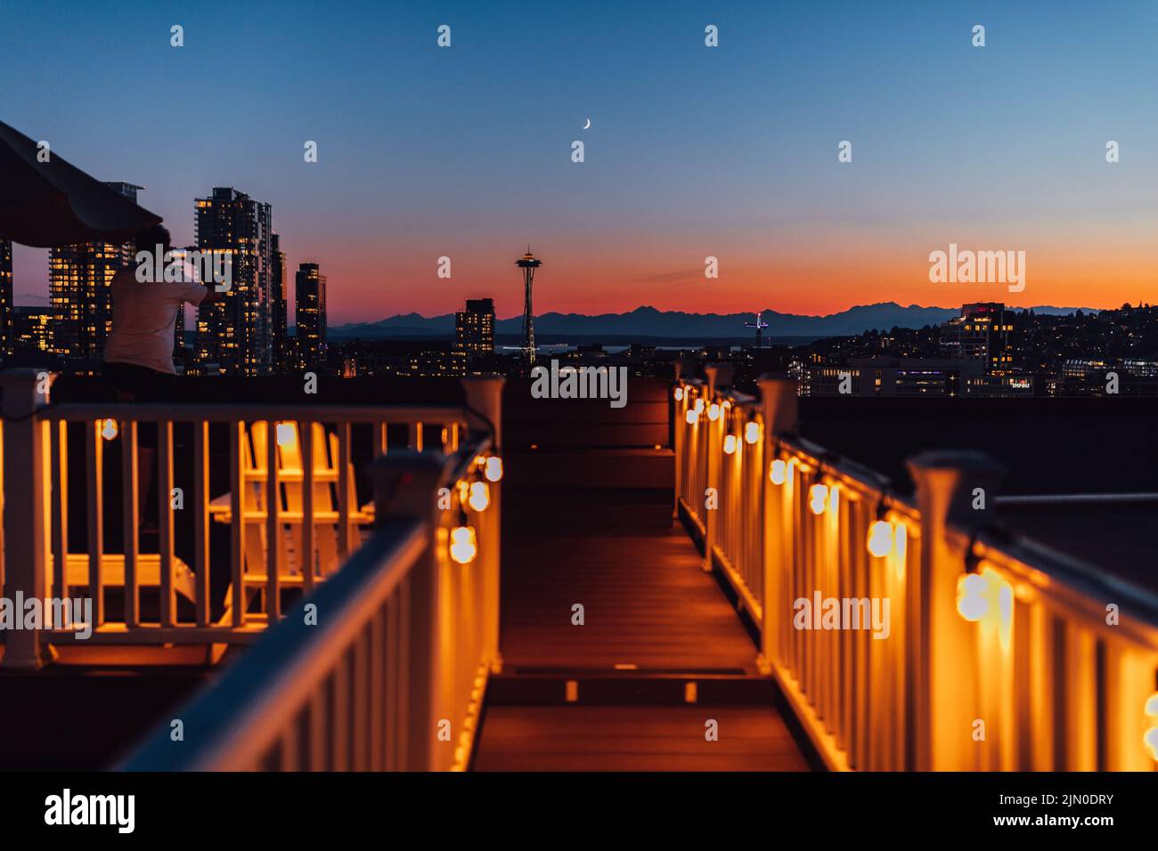 man taking phone photo of sunset with Seattle skyline from Capitol Hill ...