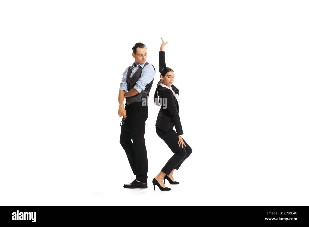 Portrait of two office workers, woman dancing near staring man isolated ...