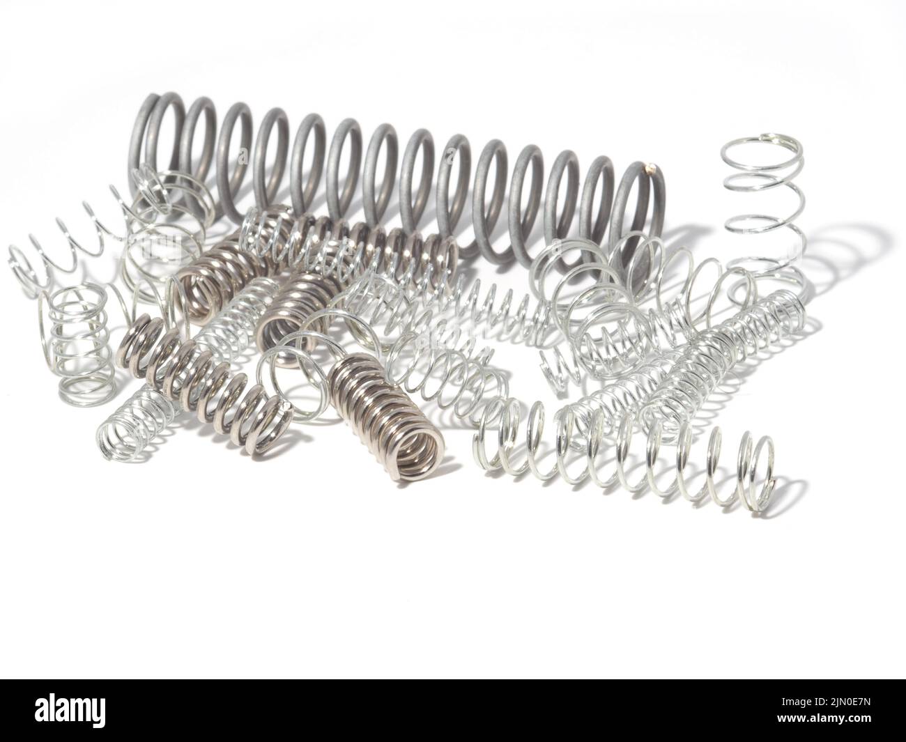 Coil springs of different size and material on a white isolated ...