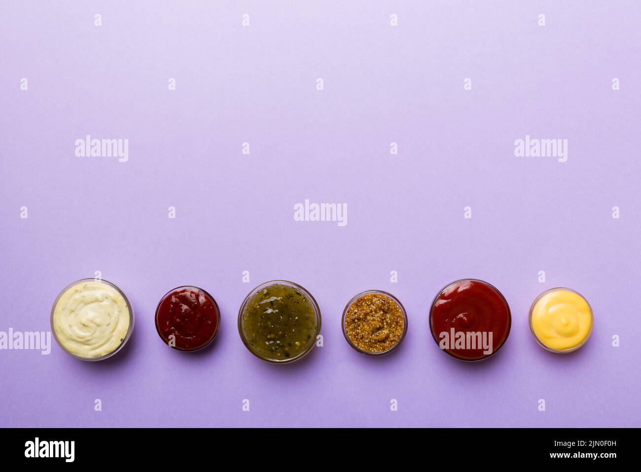 Different types of sauces in bowls on a colored Board . Top view ...