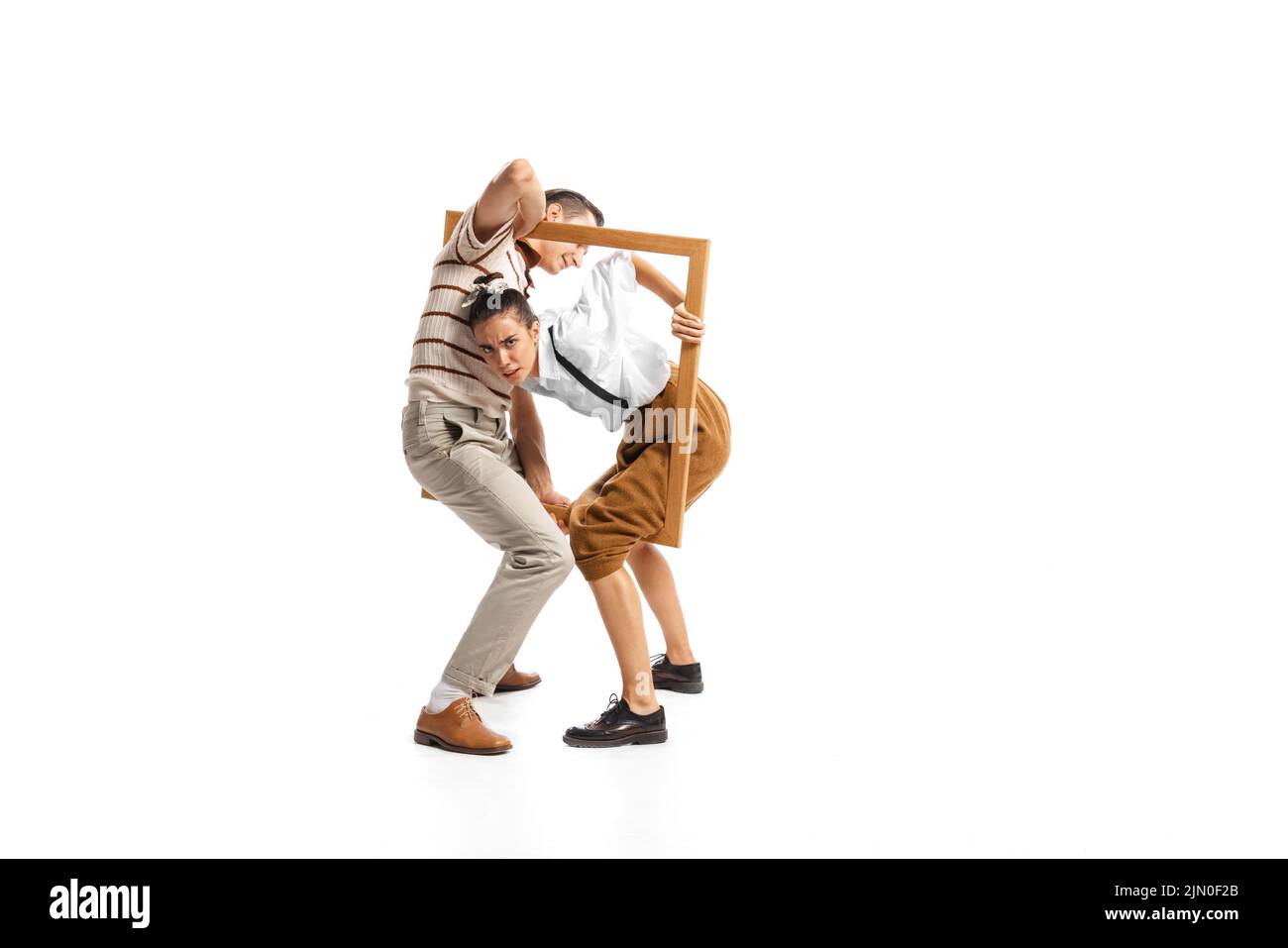 Portrait of man and woman appearing from picture frame, posing isolated ...