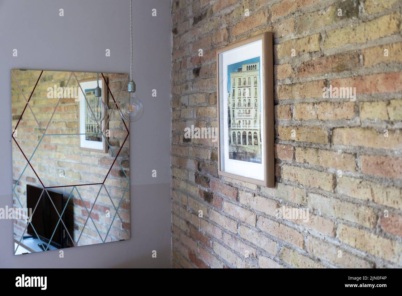Interior of a room with exposed brick wall and mirror reflecting ...