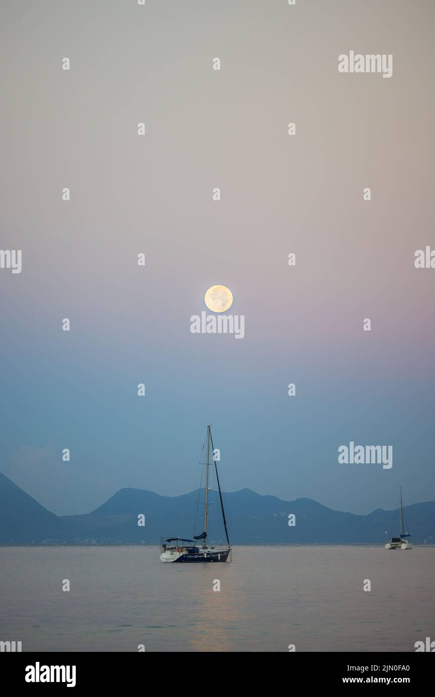 Perfect alignment between the boat and the moon going down Stock Photo ...