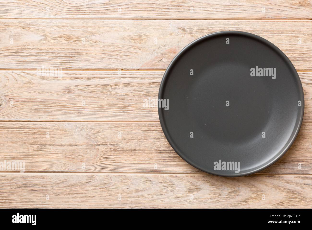 Top view of black plate on wooden background. Empty space for your ...