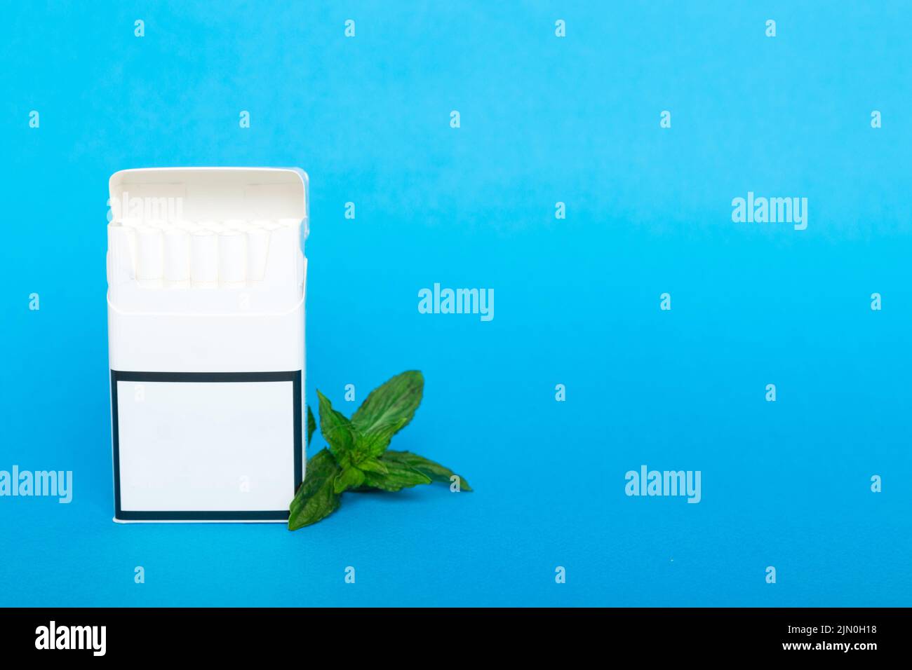 Pack of menthol cigarettes and fresh mint on colored table, Menthol ...