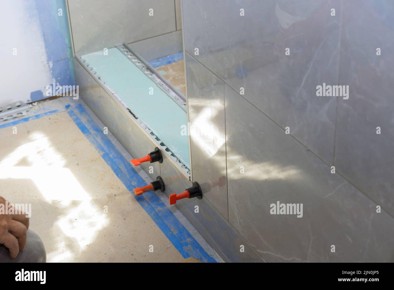 Home improvement placing ceramic tile on floor Stock Photo - Alamy