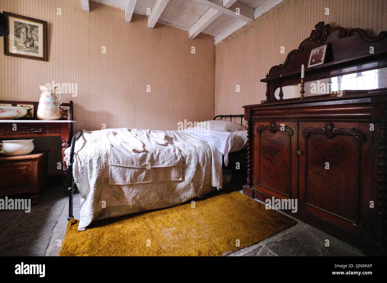 An upstairs bedroom with wash pan, pitcher and dresser. In a recreation ...