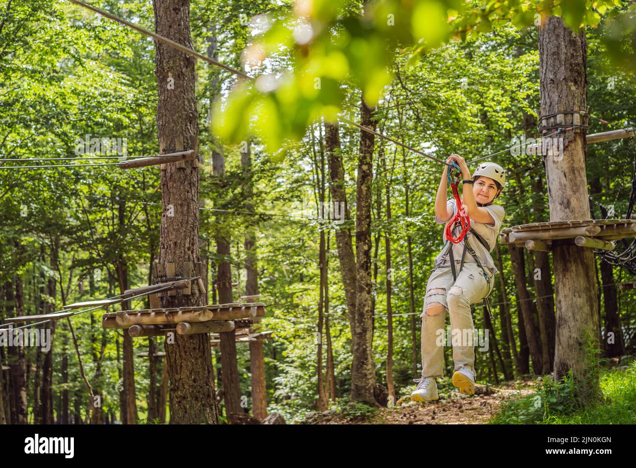 Happy women girl female gliding climbing in extreme road trolley ...