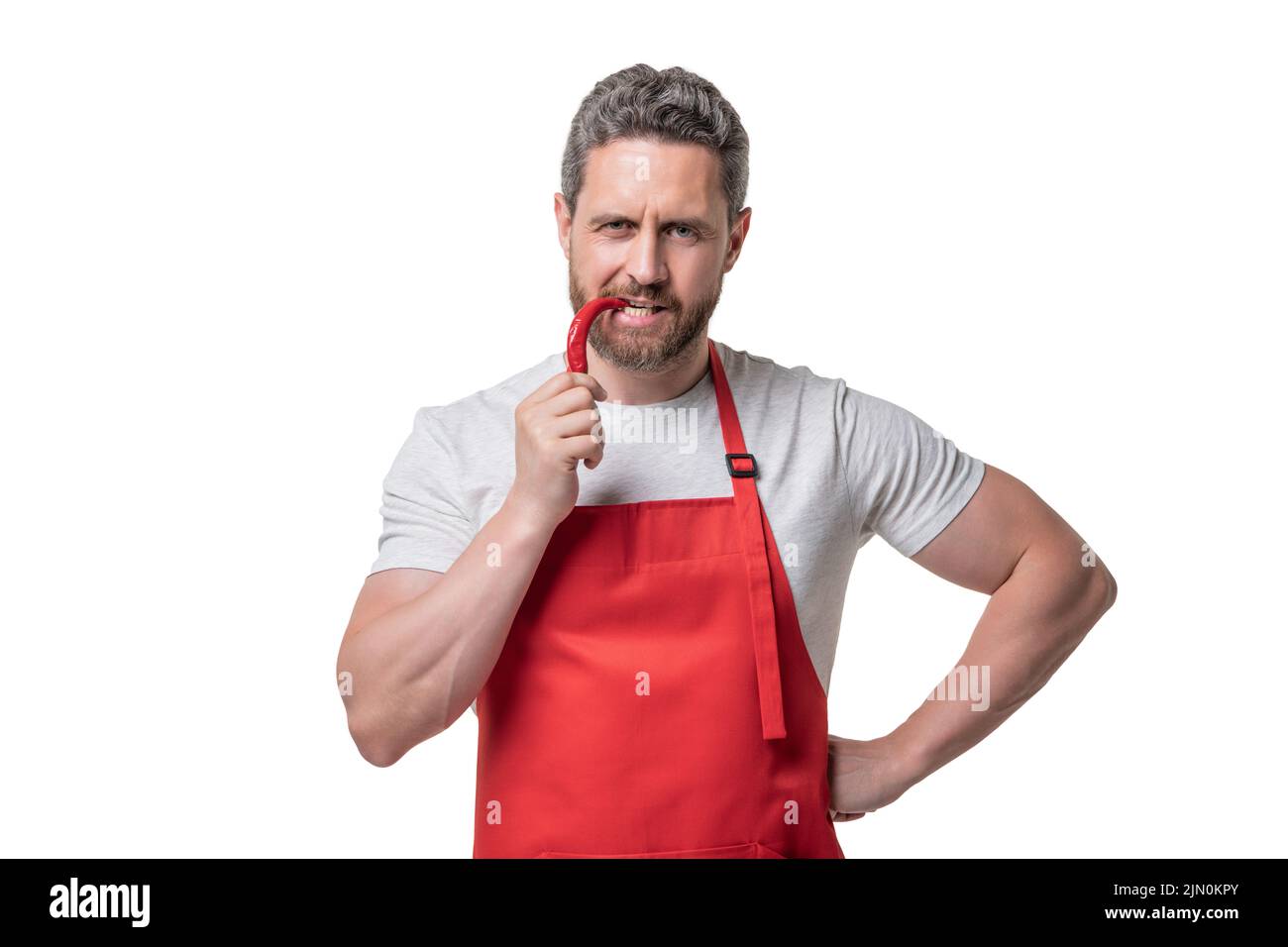 man in apron bite chili vegetable isolated on white Stock Photo - Alamy