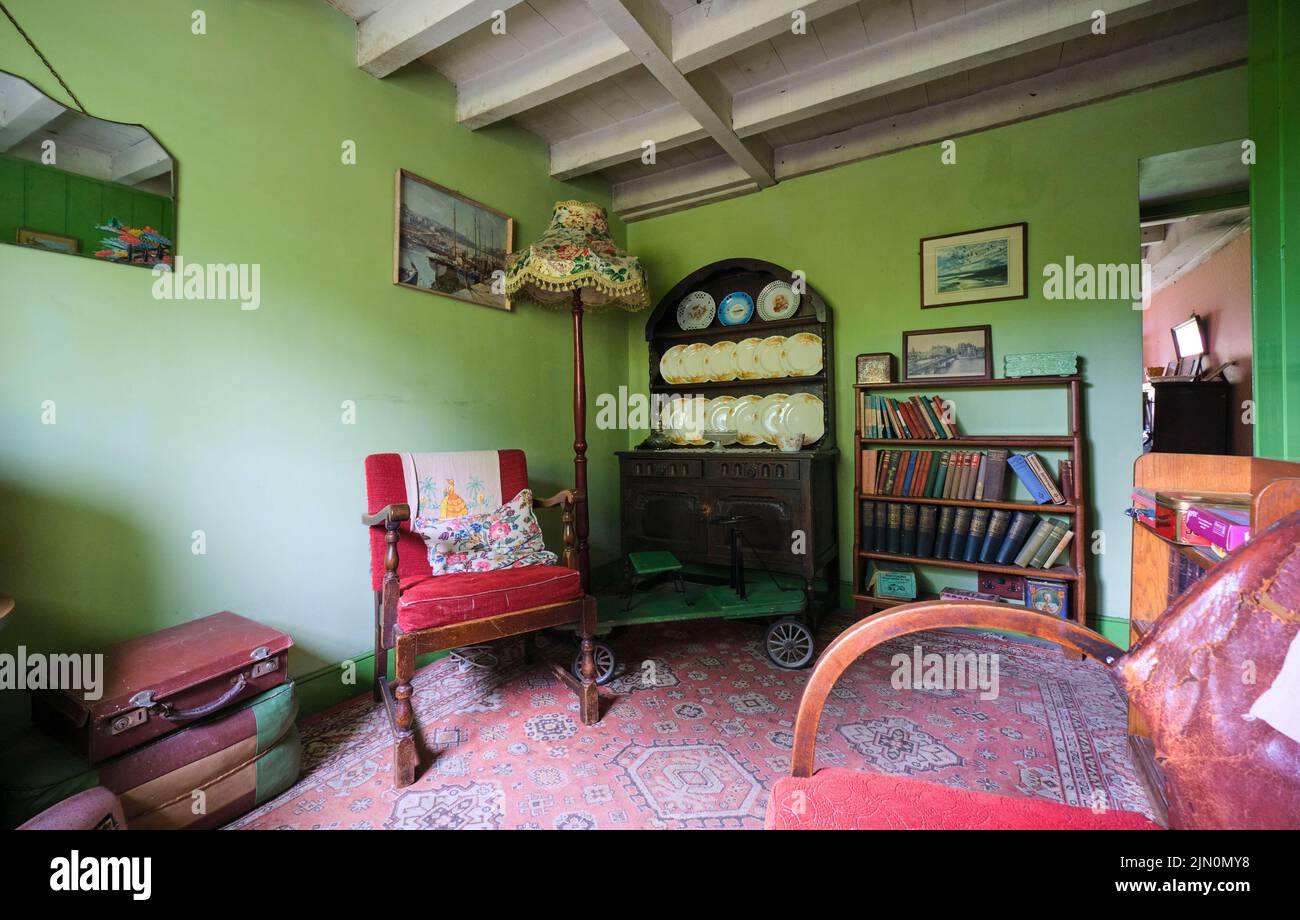 A back parlor with wood bookcase, dish display, car toy and suitcase ...
