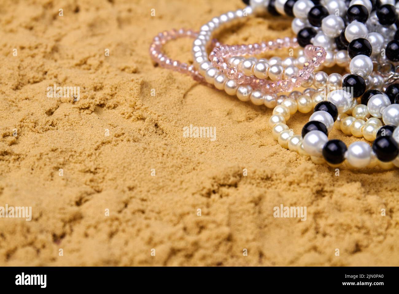 Close up pearl necklaces with copy space. Wet beach sand Stock Photo ...