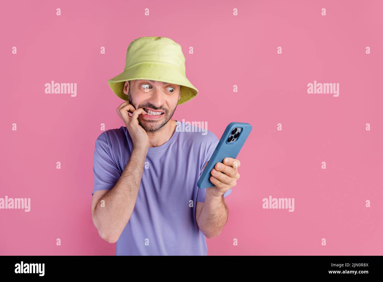 Portrait of worried frightened guy oops bite fingers use look device ...