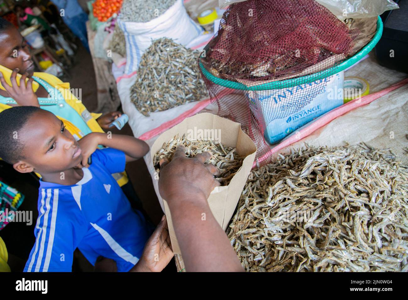 Kigali, Rwanda. 14th July, 2022. A vendor packs dried fish with a paper ...