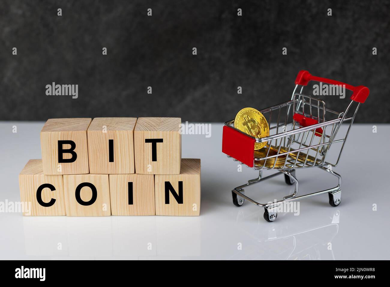 Bitcoin in shopping trolley and wooden blocks with the word bitcoin on ...