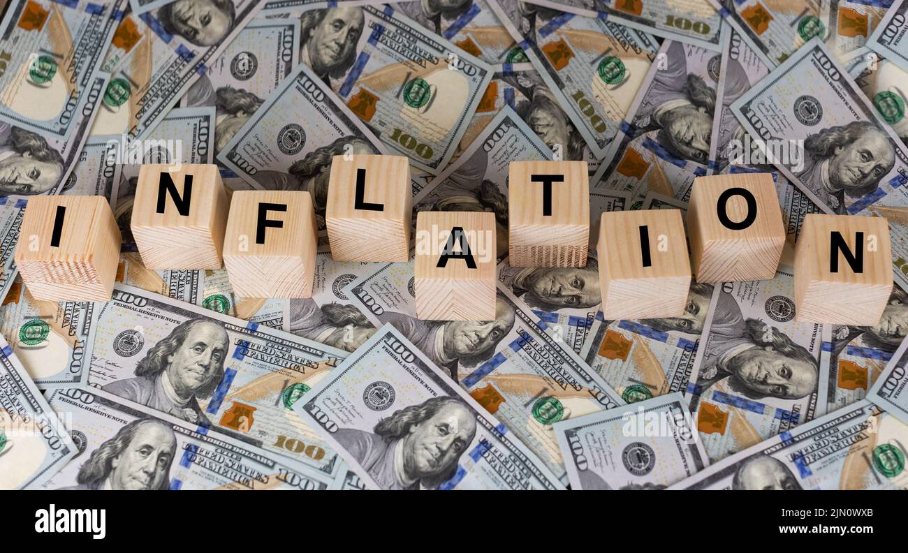 Wooden cubes with text inflation on US dollar money banknotes. The idea ...