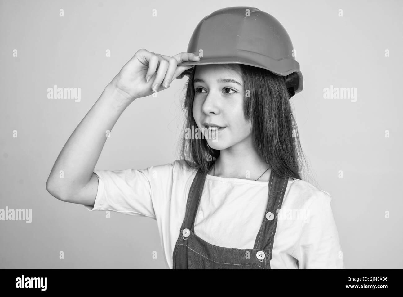teen girl in helmet and boilersuit. child wear hard hat. kid builder on ...