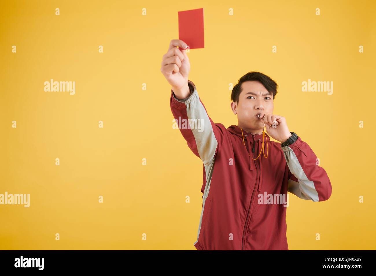 Serious football referee whistling and showing red card Stock Photo - Alamy