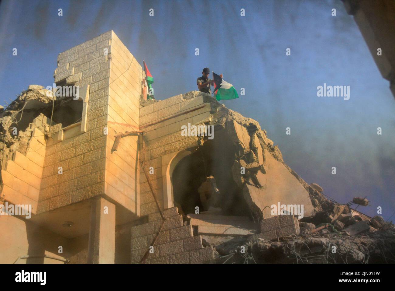 A man hangs a Palestinian flag on the house of Subhi Sbeihat, following ...