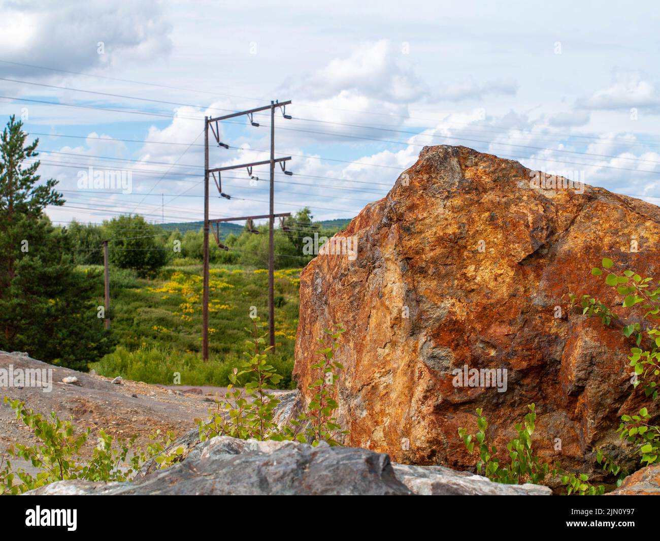 Large orange rock in front of vintage electric wiring in summer ...