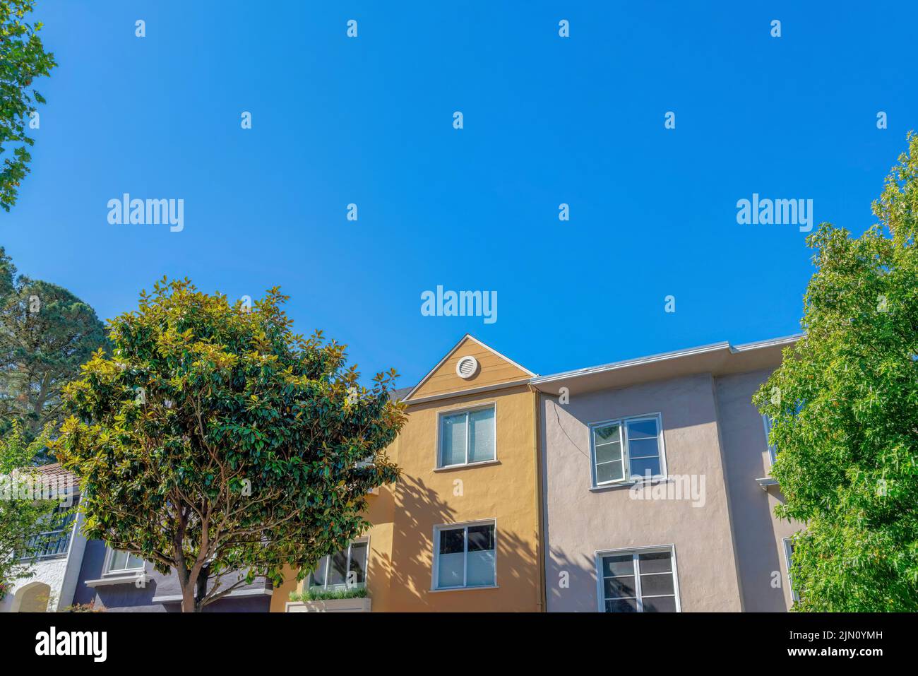 Facade of adjacent houses with painted stucco walls at San Francisco ...