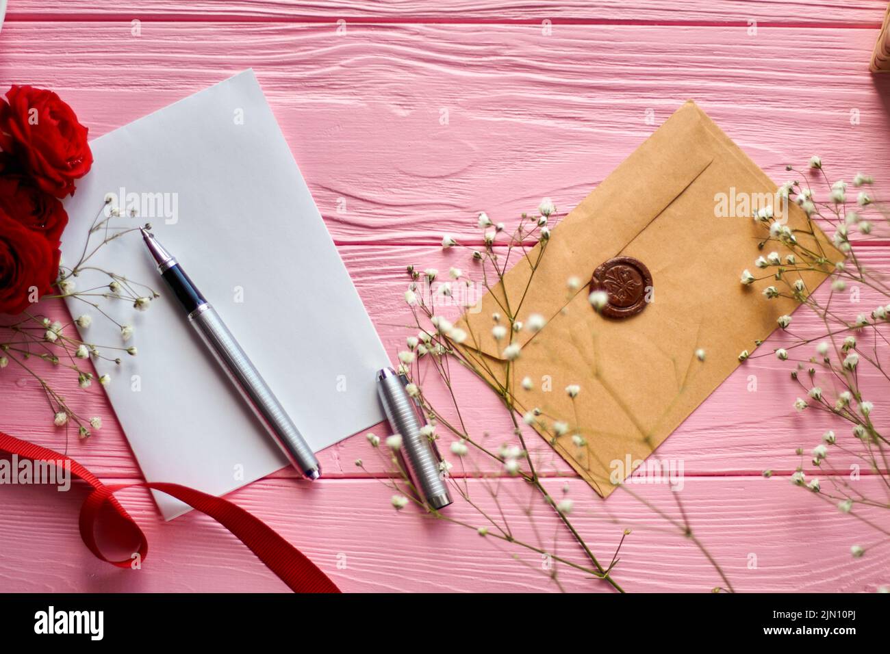 Top view beige envelope with blank paper. Pink wooden desk Stock Photo ...