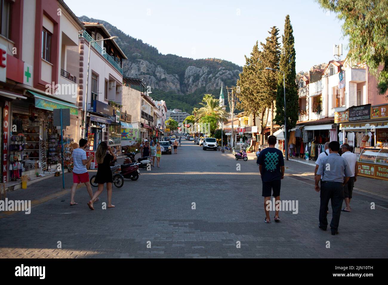 Tourists walk past a cafeteria and souvenir store in small resort town ...