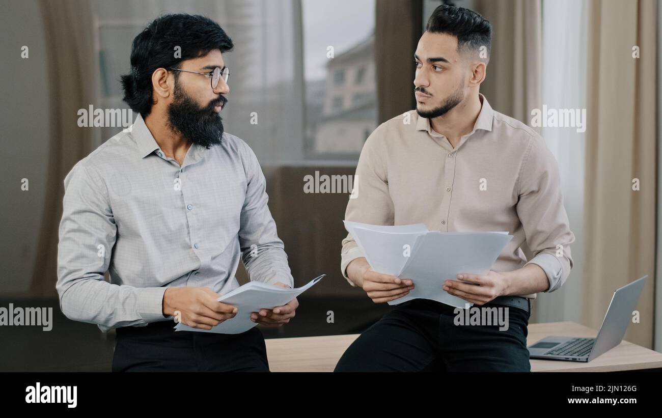 Multiracial diverse co-workers businessmen partners sit on desk ...
