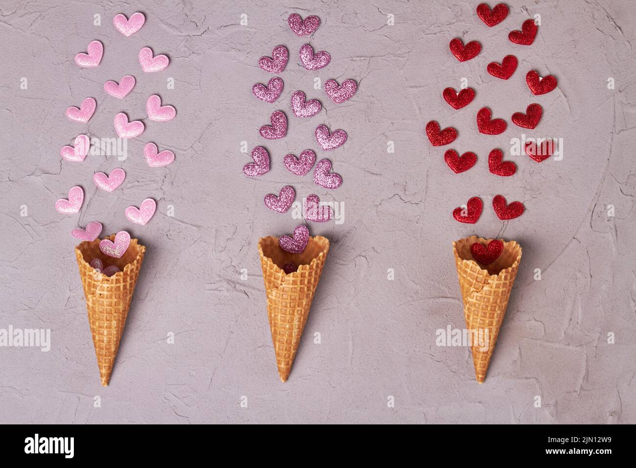 Three ice cream horn cones with sequin hearts. Valentines day or ...
