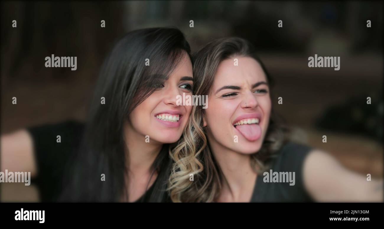 Girlfriends taking selfie sticking tongue out Young women posing for ...