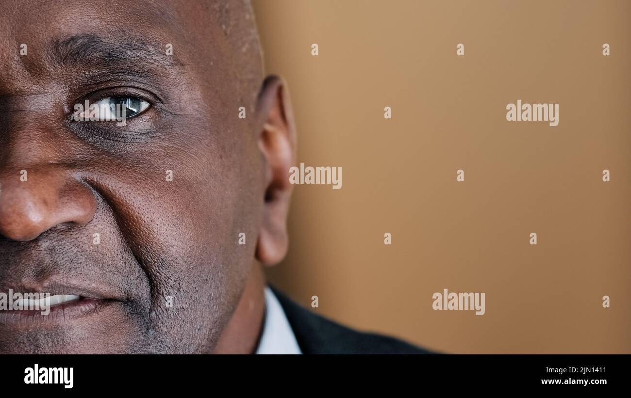 Closeup headshot half male face portrait serious mature African man ...